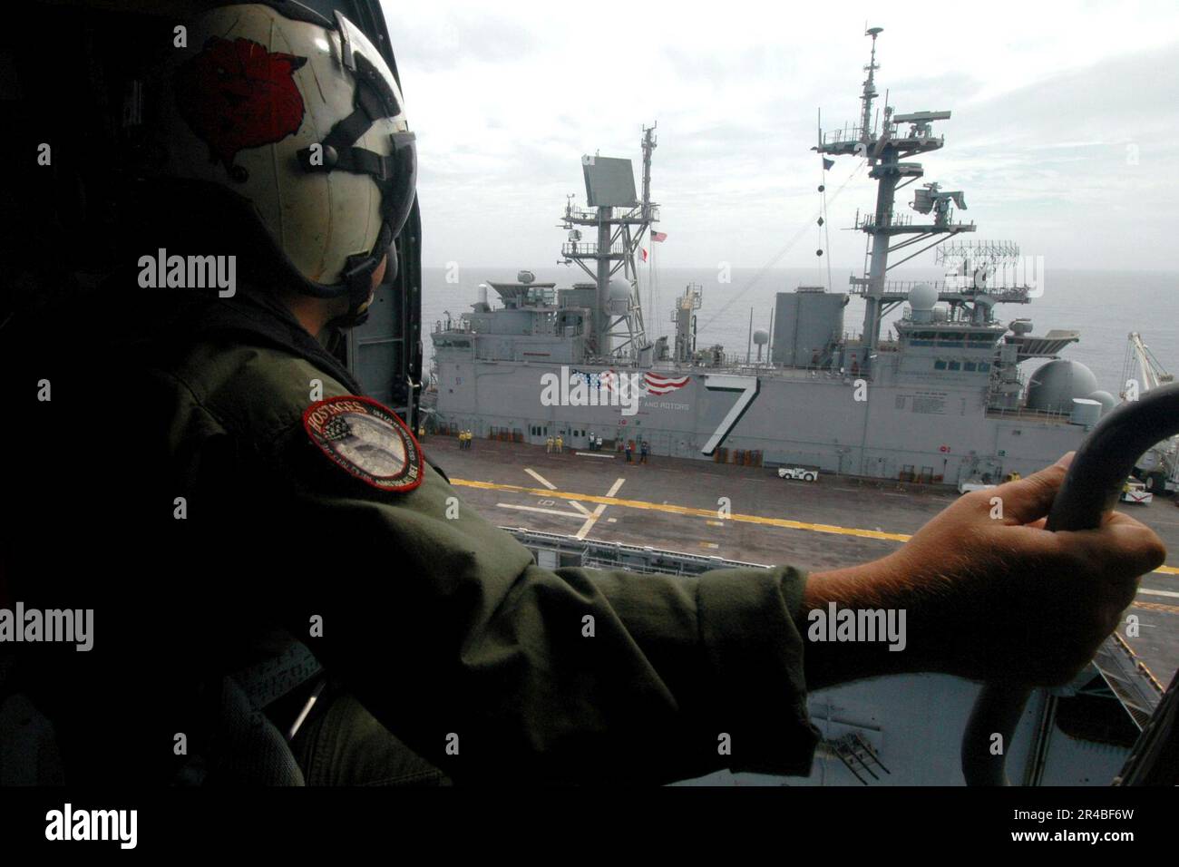 US Navy An air crewman looks out the cabin door of his MH-60S Seahawk ...