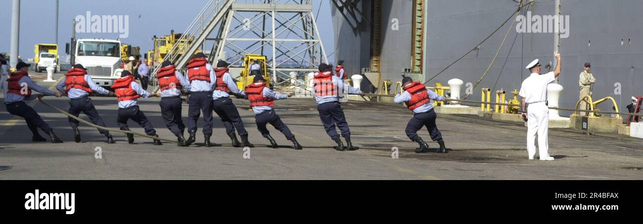 US Navy Line handlers haul the brow of the amphibious assault ship USS ...