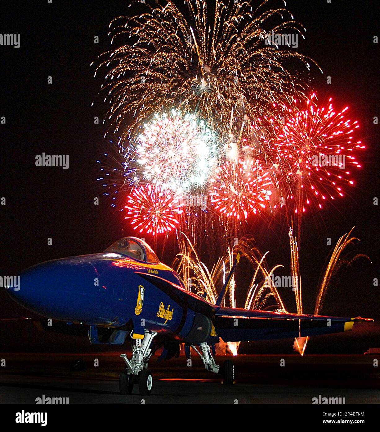 US Navy Fireworks explode and highlight an F-A-18A Hornet, assigned to ...