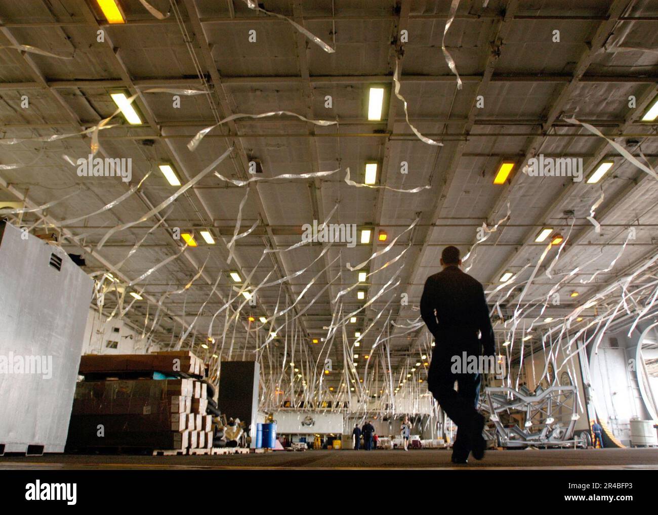 US Navy A Sailor walks through the hangar bay of the nuclear-powered ...