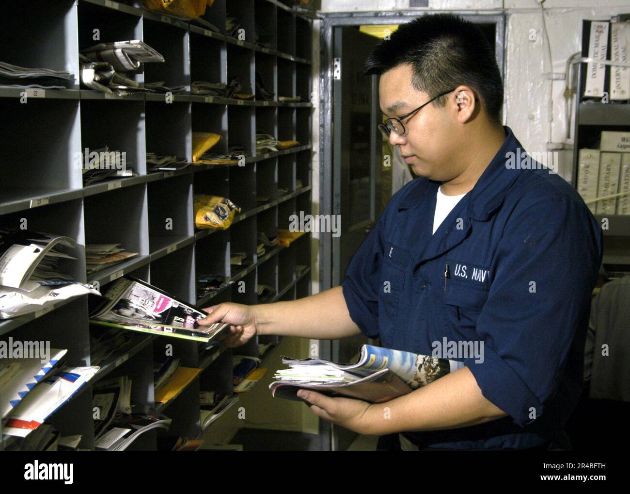 US Navy Postal Clerk Seaman sorts mail in the post office aboard the ...