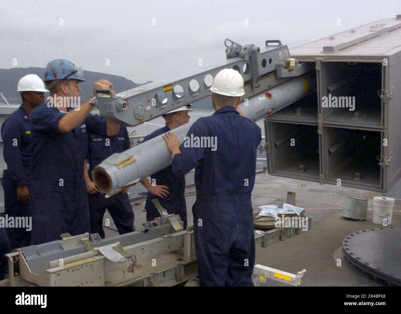 US Navy Fire Controlman upload a RIM-7 NATO Sea Sparrow missile into a ...