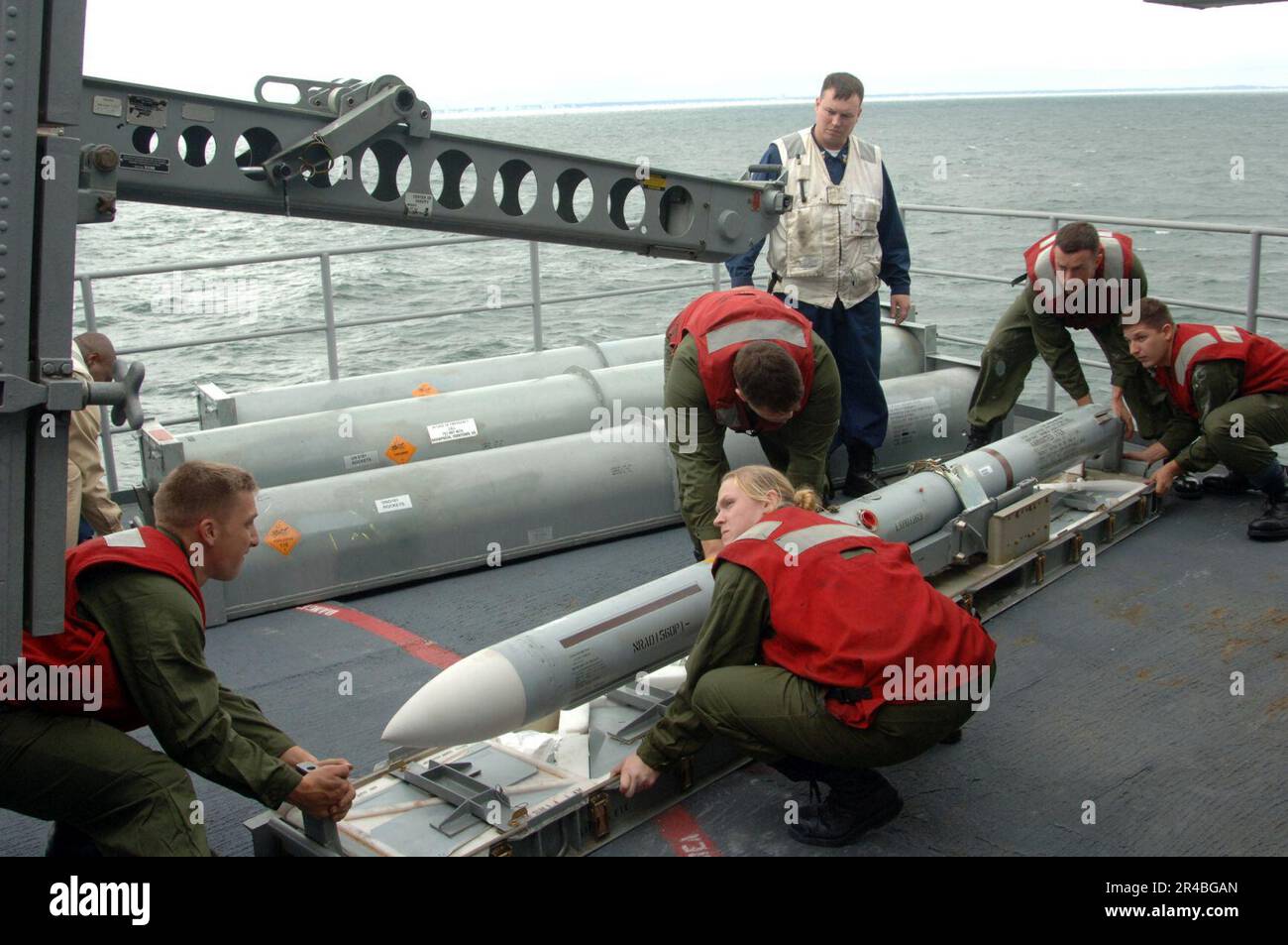 US Navy Fire Controlmen position a RIM-7 NATO Sea Sparrow missile as ...