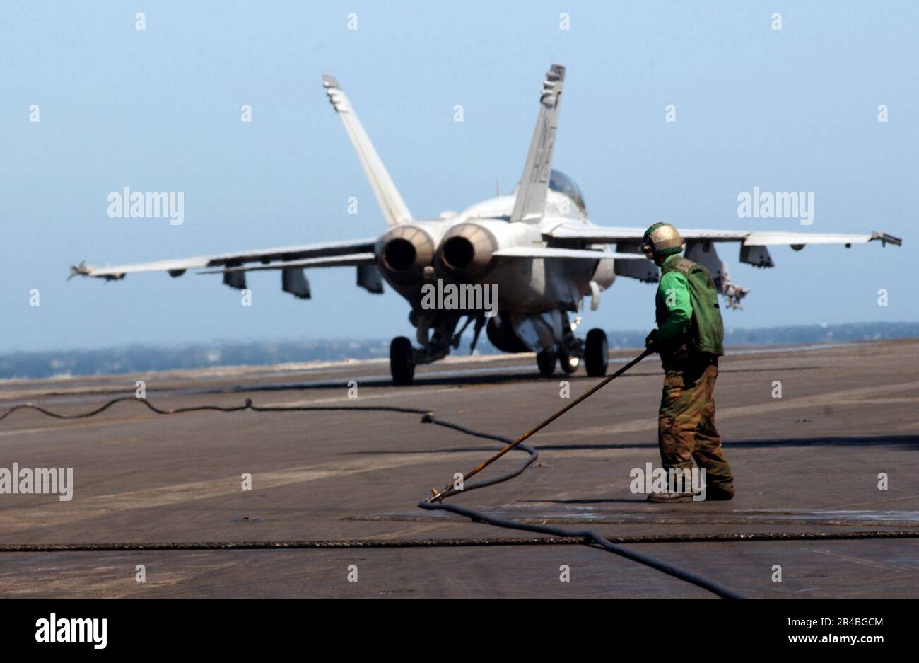 US Navy Airman pushes the arresting gear wire after the landing of an F ...