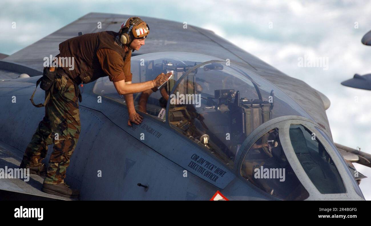 US Navy A plane captain cleans the canopy of an F-14D Tomcat, assigned ...