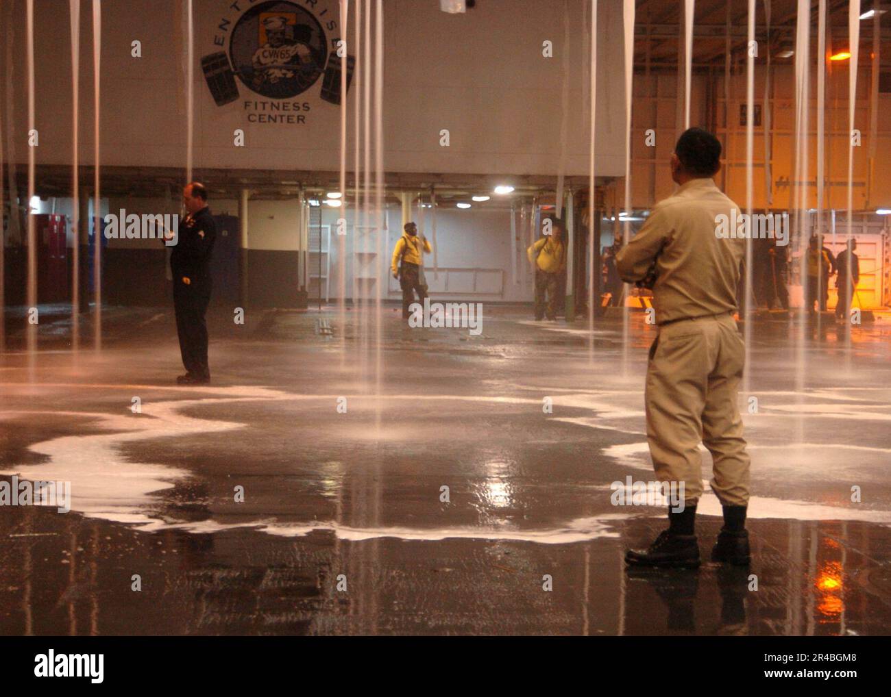 US Navy Air Department personnel observe a test of the Aqueous Film ...