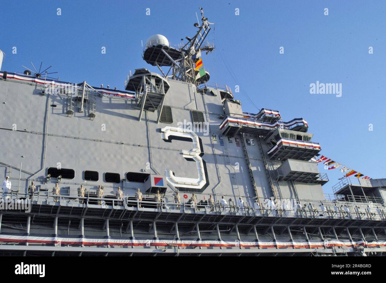 US Navy Crew members man the rails of the amphibious assault ship USS ...