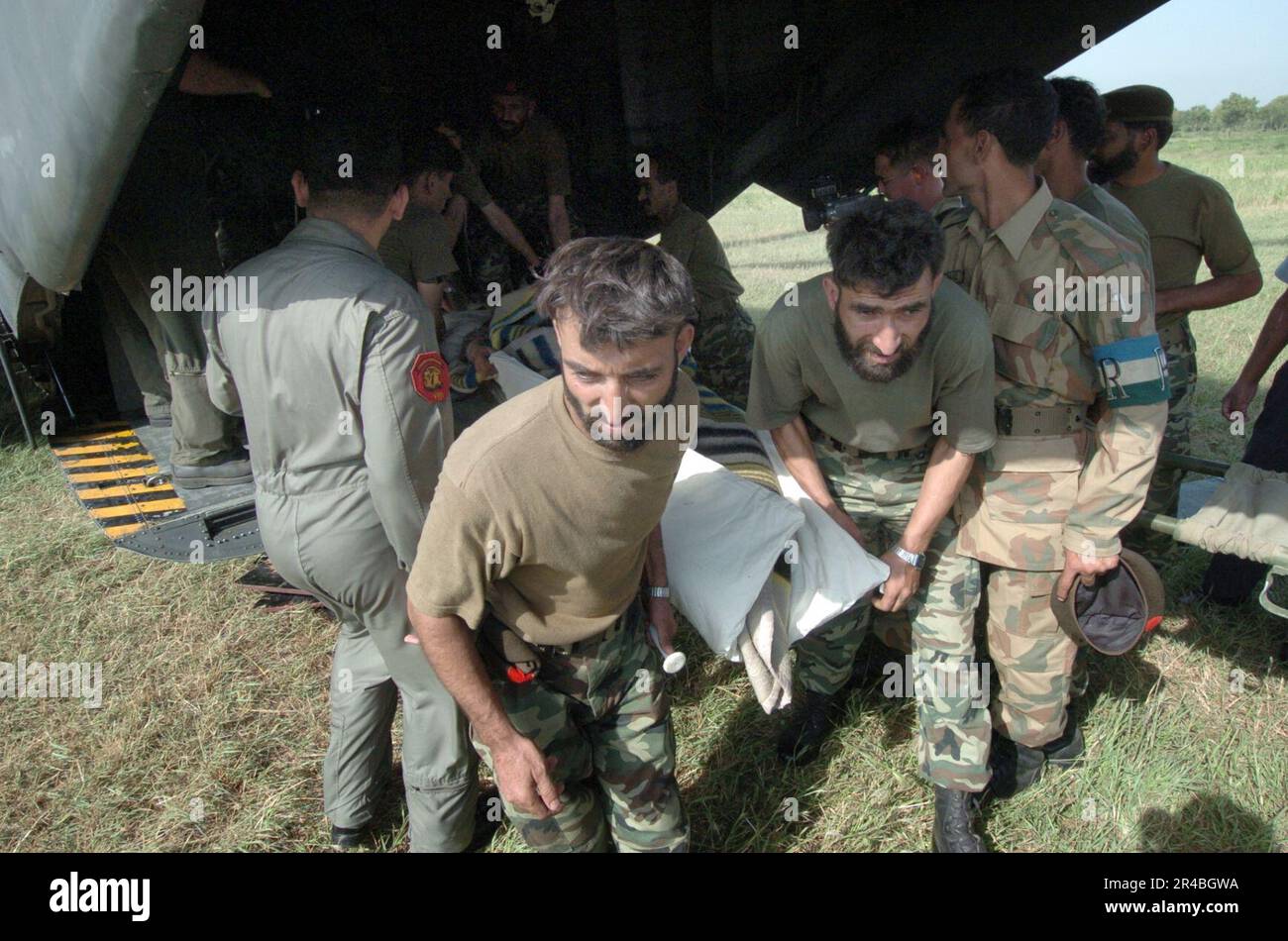US Navy Pakistani soldiers carry an injured woman off of a U.S. Navy MH ...