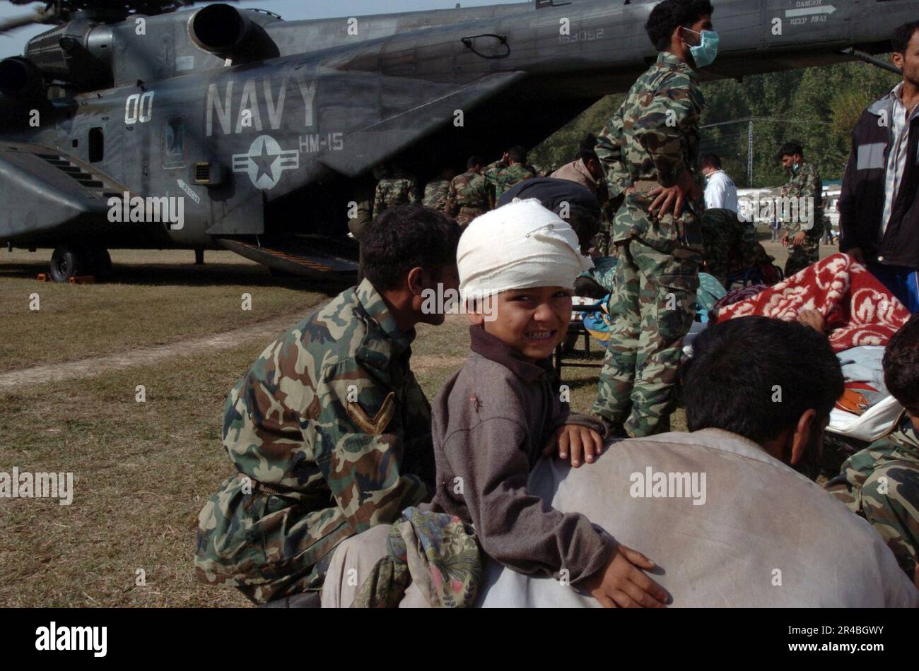 US Navy An injured Pakistani boy is carried by his father to a U.S ...