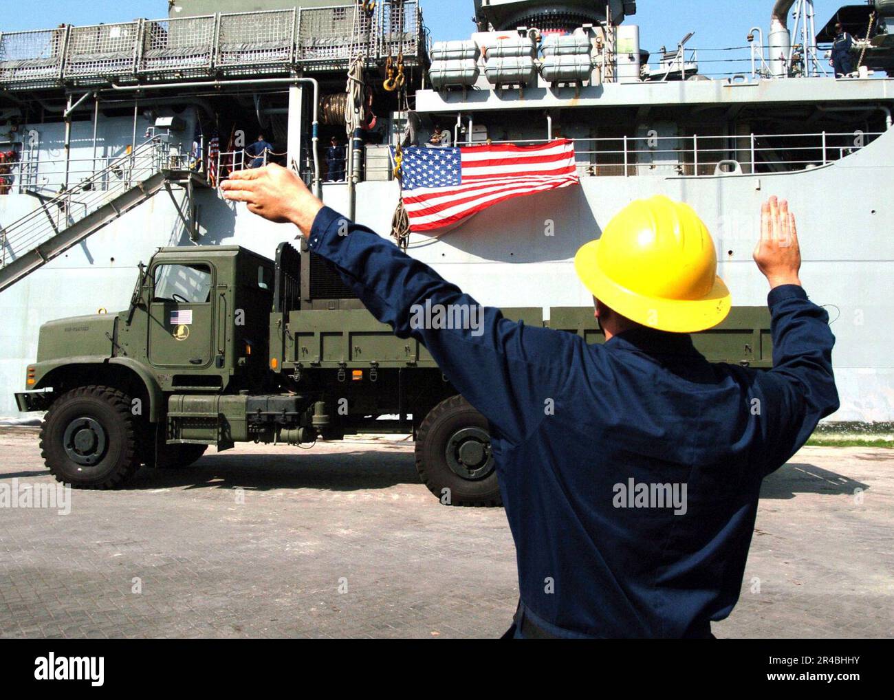 US Navy U.S. Navy Boatswain's Mate 2nd Class directs a crane carrying a ...