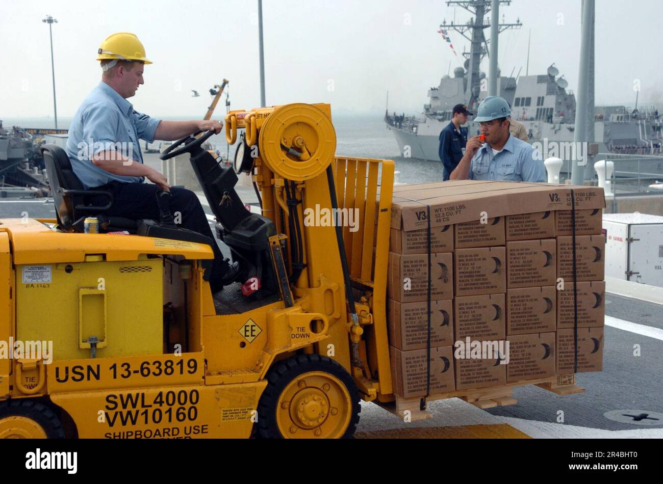 US Navy Boatswain's Mate Seaman directs Boatswain's 2nd Class as he ...
