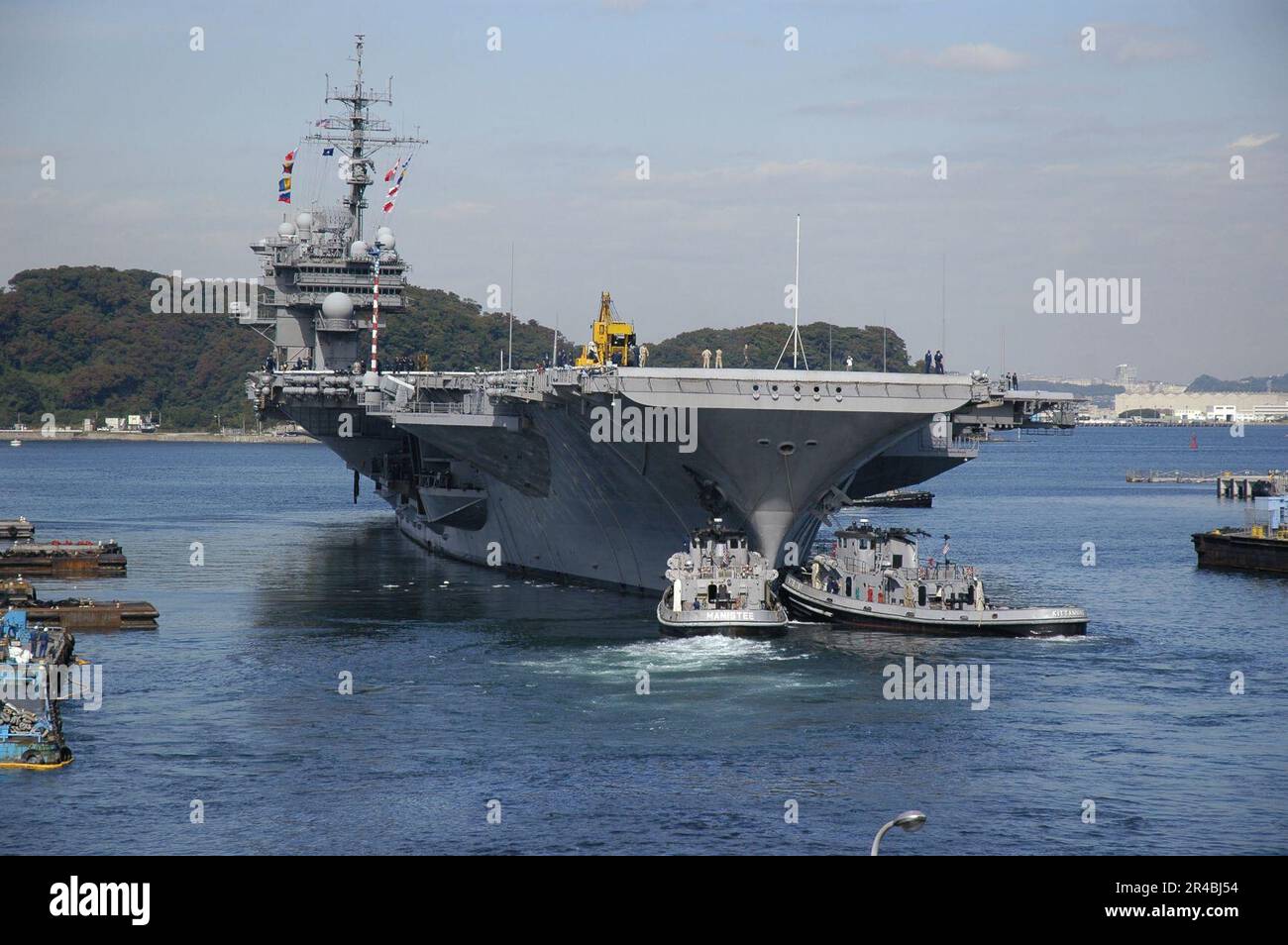 US Navy Assisted by two harbor tug boats, the conventionally powered ...