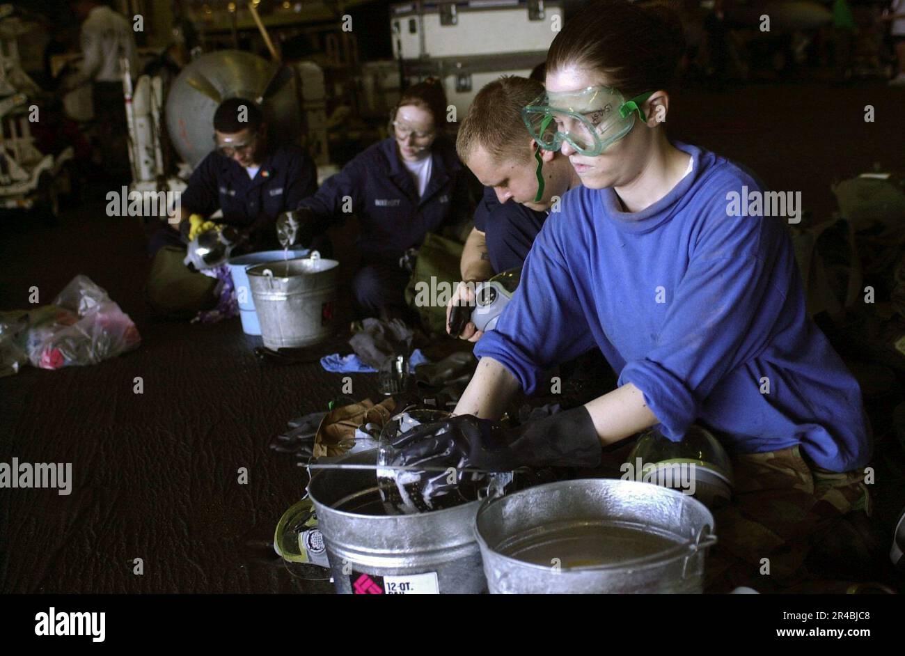 US Navy Crew members sanitize MCU-2P gas masks in the hangar bay aboard ...