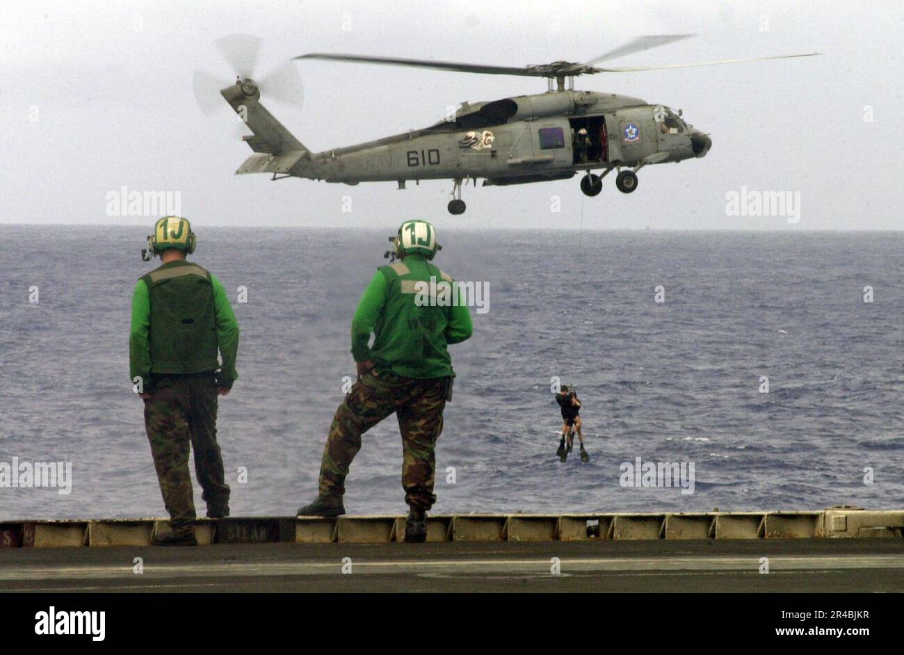 US Navy Crew members watch an SH-60F Seahawk helicopter, assigned to ...