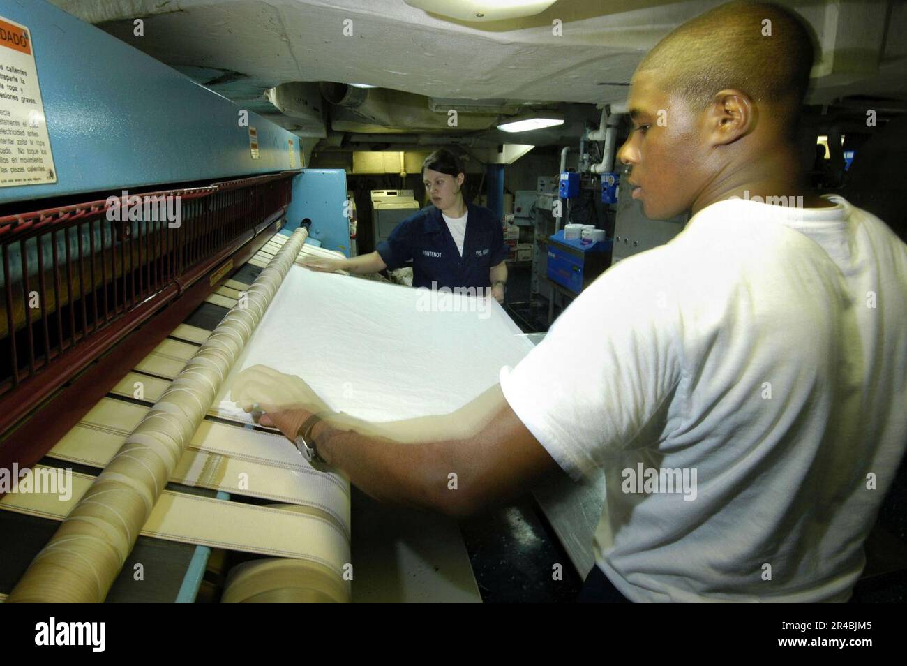 US Navy Airman foreground, and Aviation Electrician's Mate fold linen ...