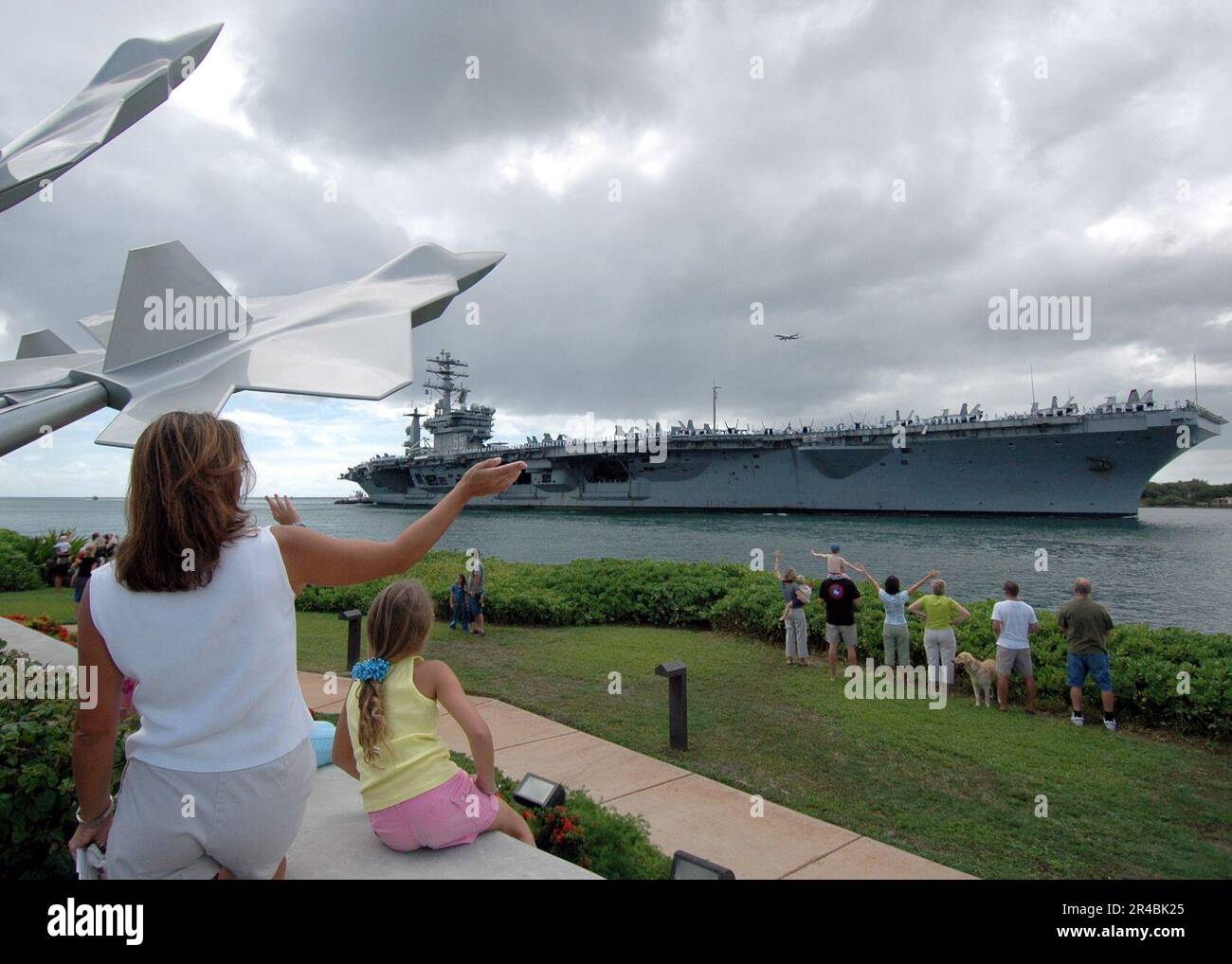 US Navy Family members wave to the nuclear-powered aircraft carrier USS ...