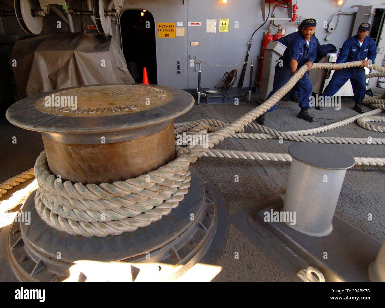 US Navy Sailors assigned to Deck Department pull a mooring line while ...