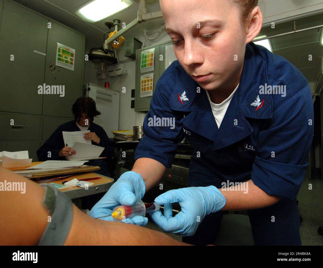 US Navy Hospital Corpsman 3rd Class draws blood for an HIV test from a ...