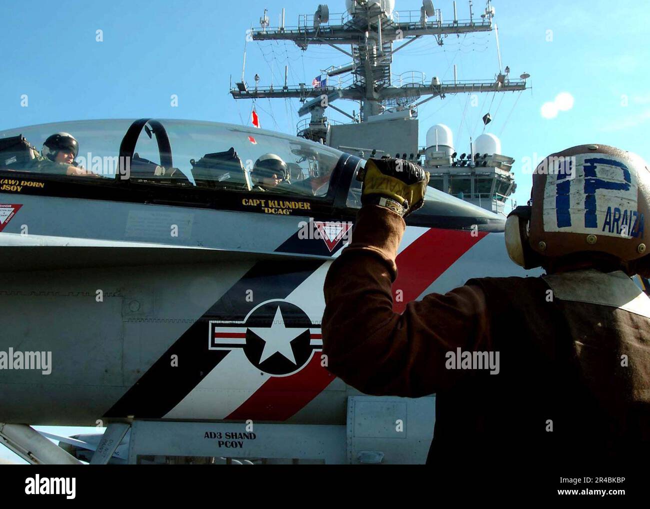 US Navy A plane captain ignals to the crew in one of his squadron's F-A ...