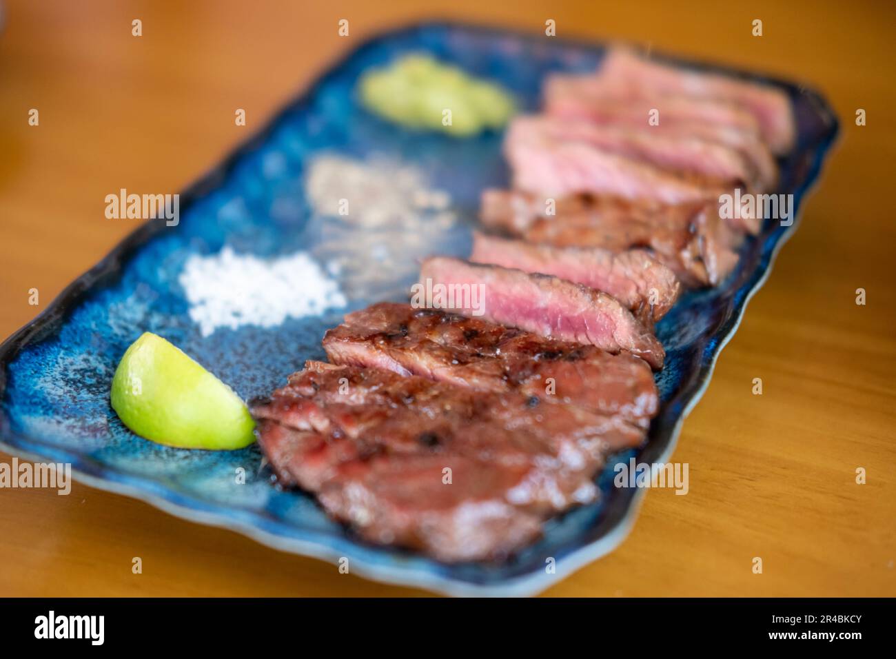 Medium rare meat on plate with salt and pepper Stock Photo - Alamy