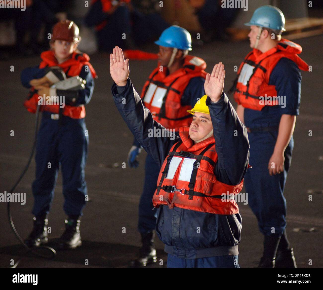 US Navy A Sailor assigned to Deck Department signals the Military ...