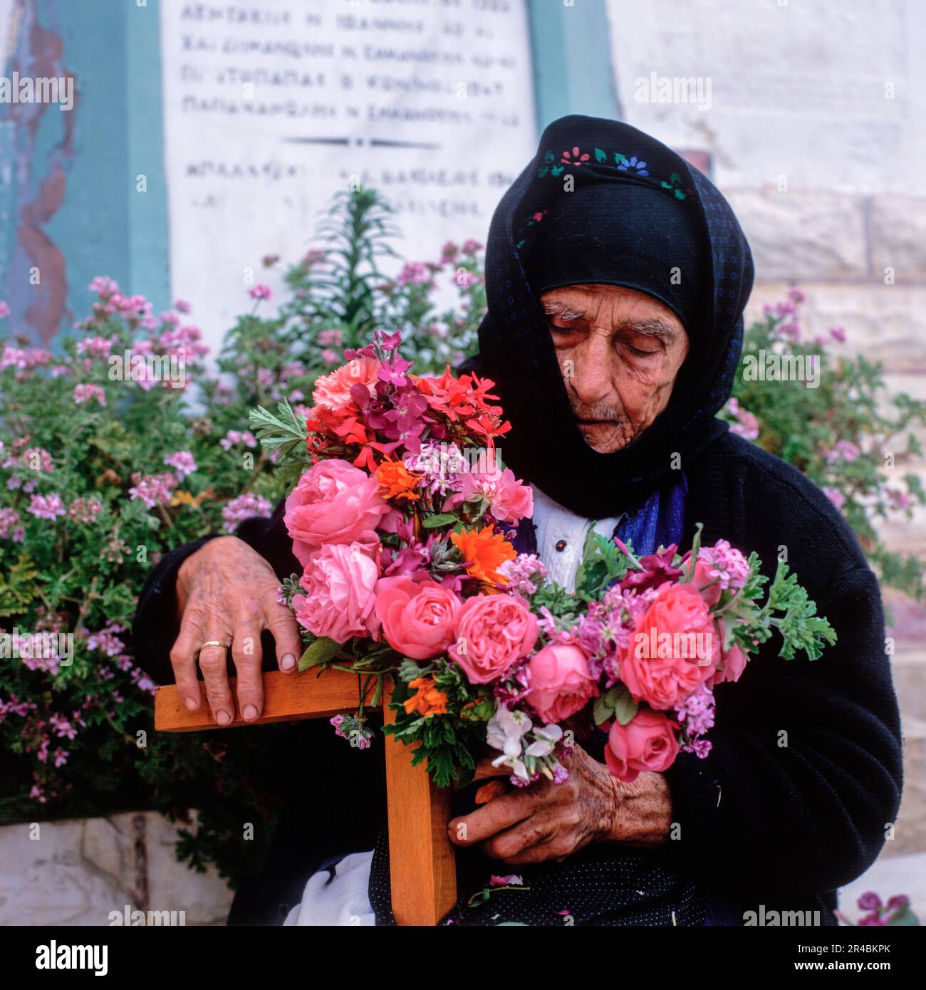Olymbos, Good Friday, woman decorating a wooden cross for the epitaph ...