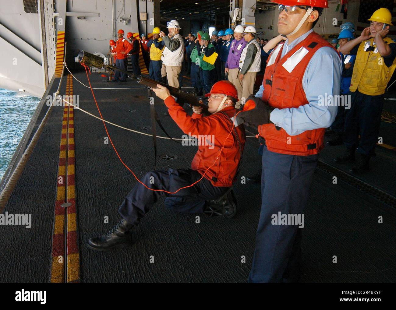US Navy Gunner's Mate 1st Class takes aim to send the line from the ...