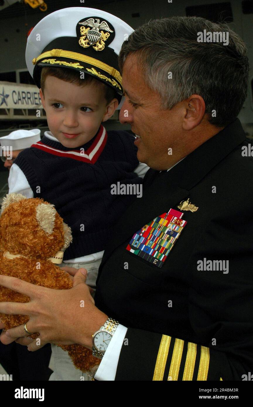 US Navy Commander, Destroyer Squadron Two Three, gives his son a teddy ...