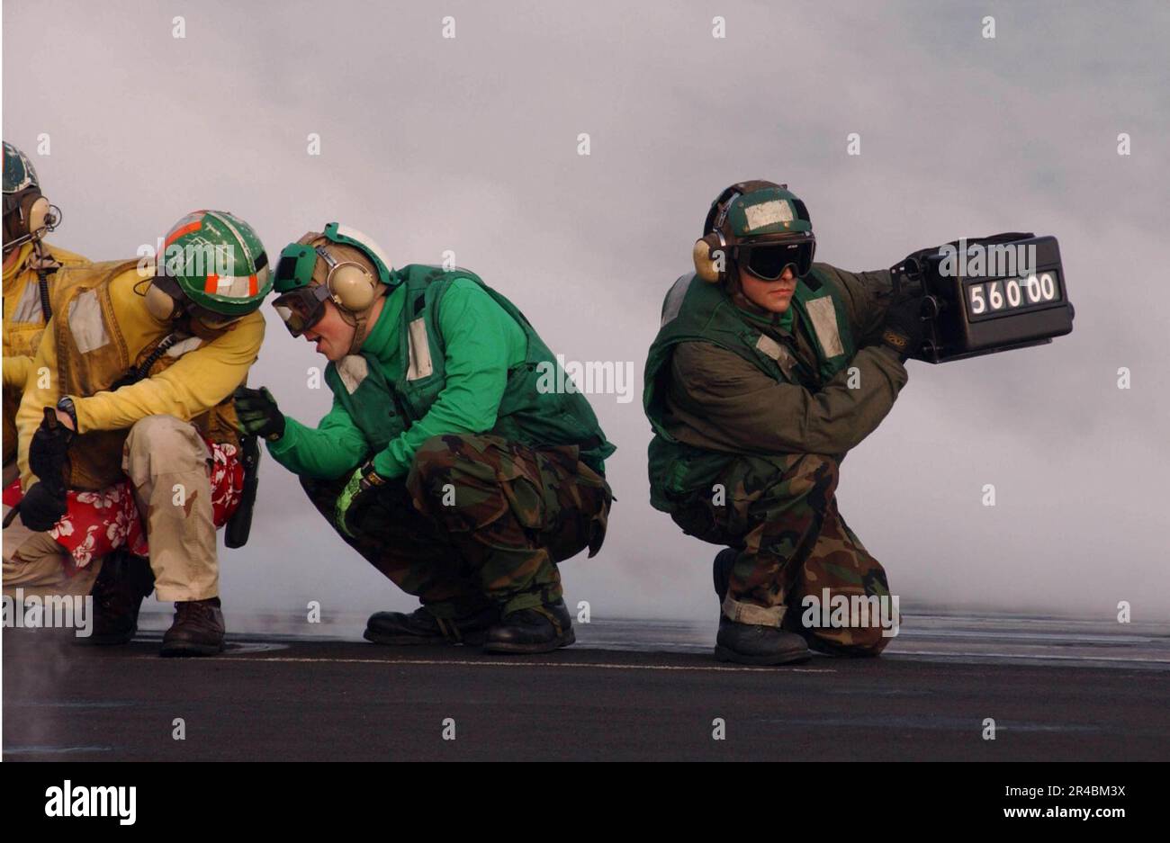 US Navy Air Department personnel hold-up a weight box as they prepare ...