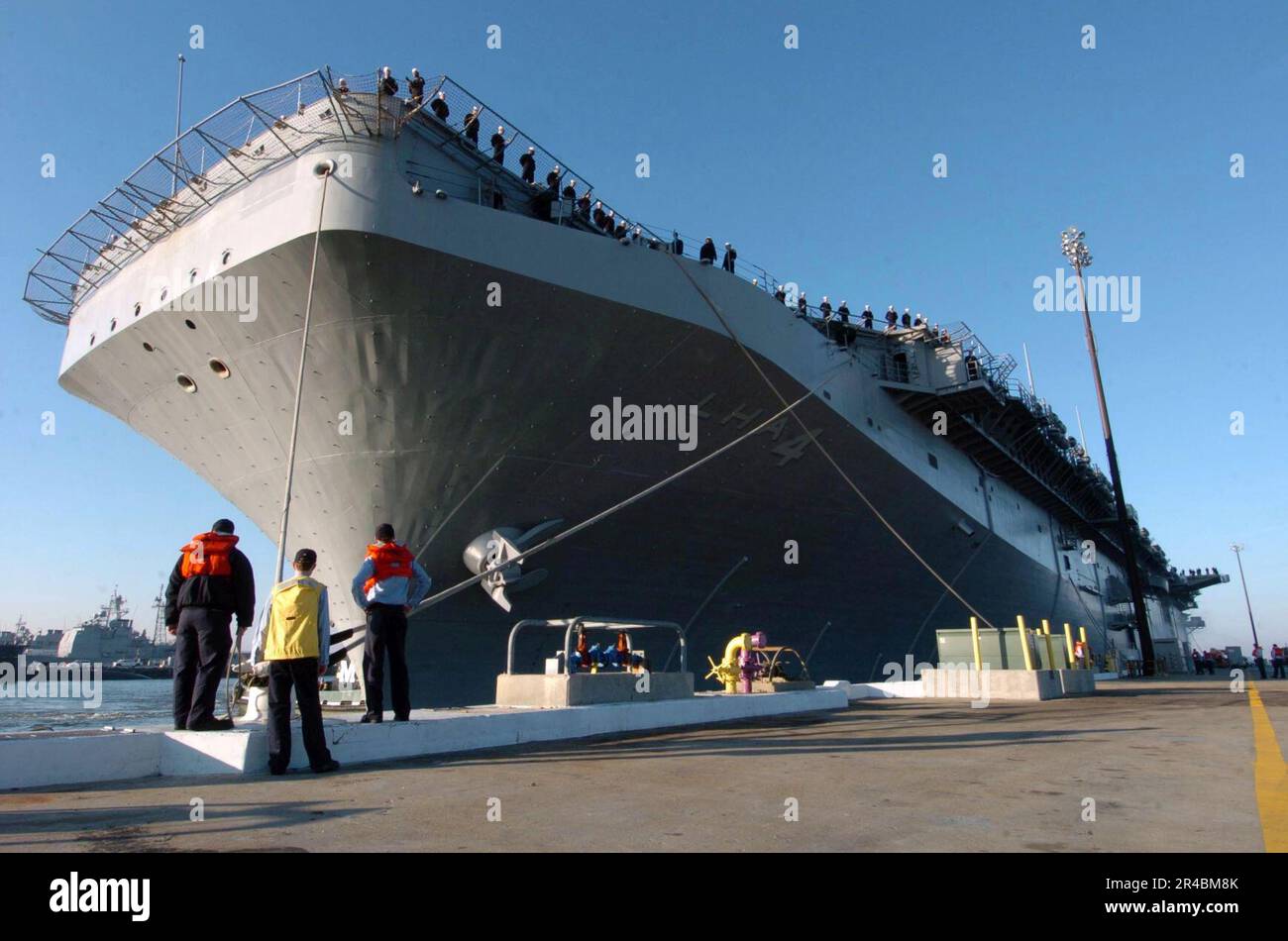 US Navy Line handlers assigned to USS Bataan (LHD 5), prepare to cast ...