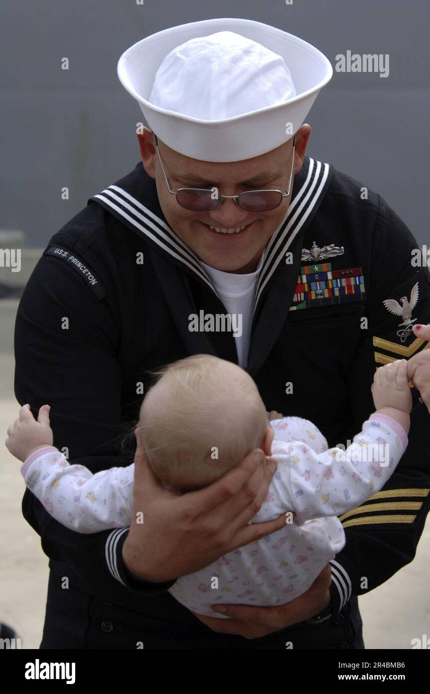 US Navy Electrician's Mate 1st Class holds his six-month-old baby girl ...