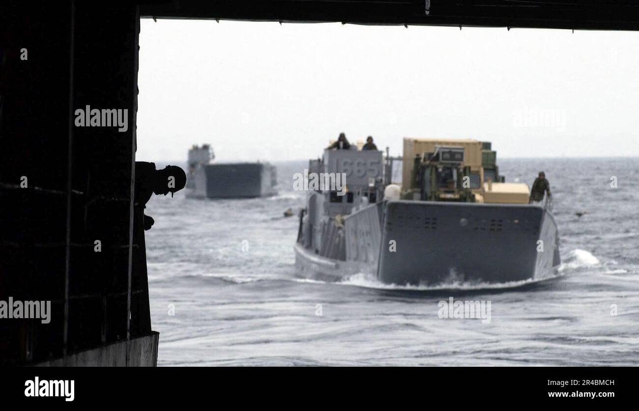 US Navy A Deck Department Sailor checks the water level of the well ...