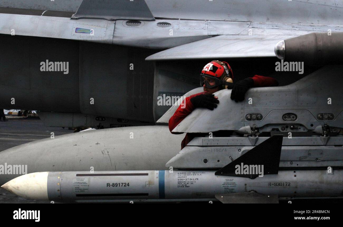 US Navy An Aviation Ordnanceman positions himself next to an AIM-7 ...