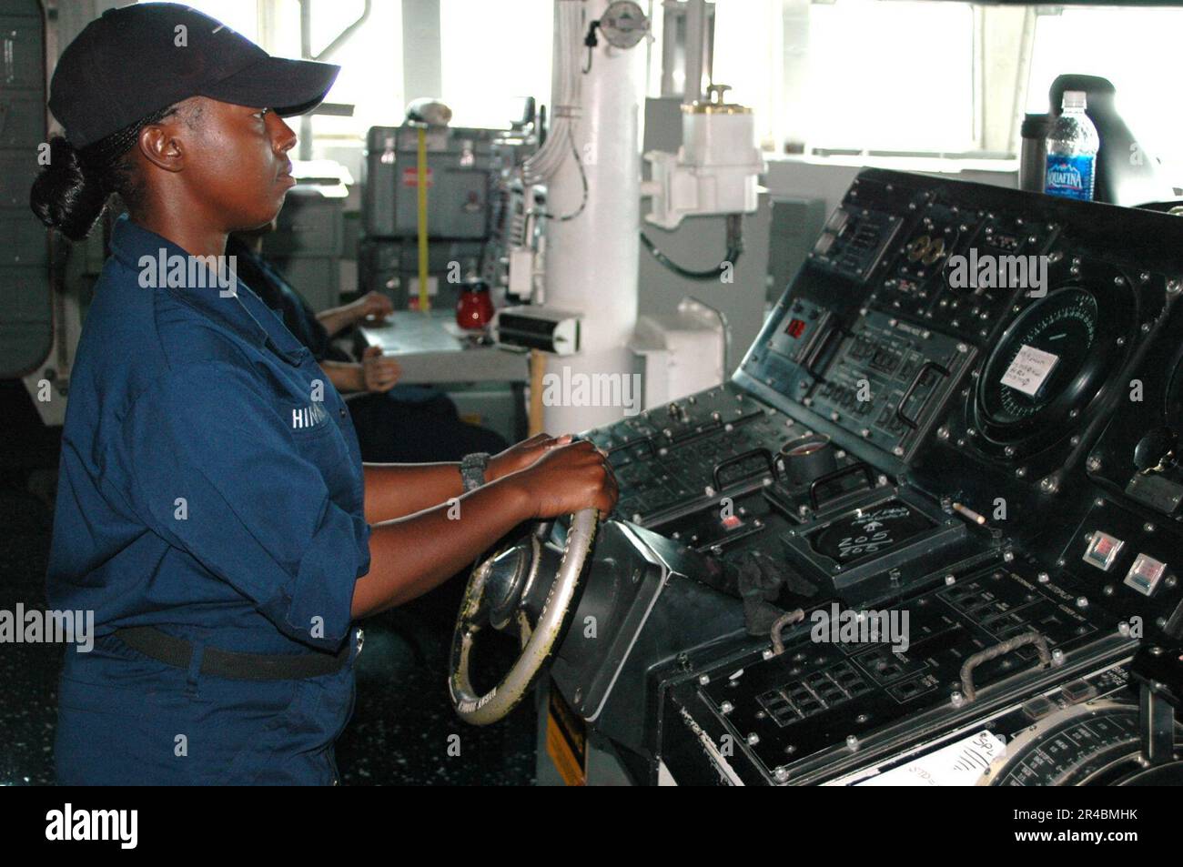 US Navy Journalist 3rd Class performs helmsman duties on the bridge ...