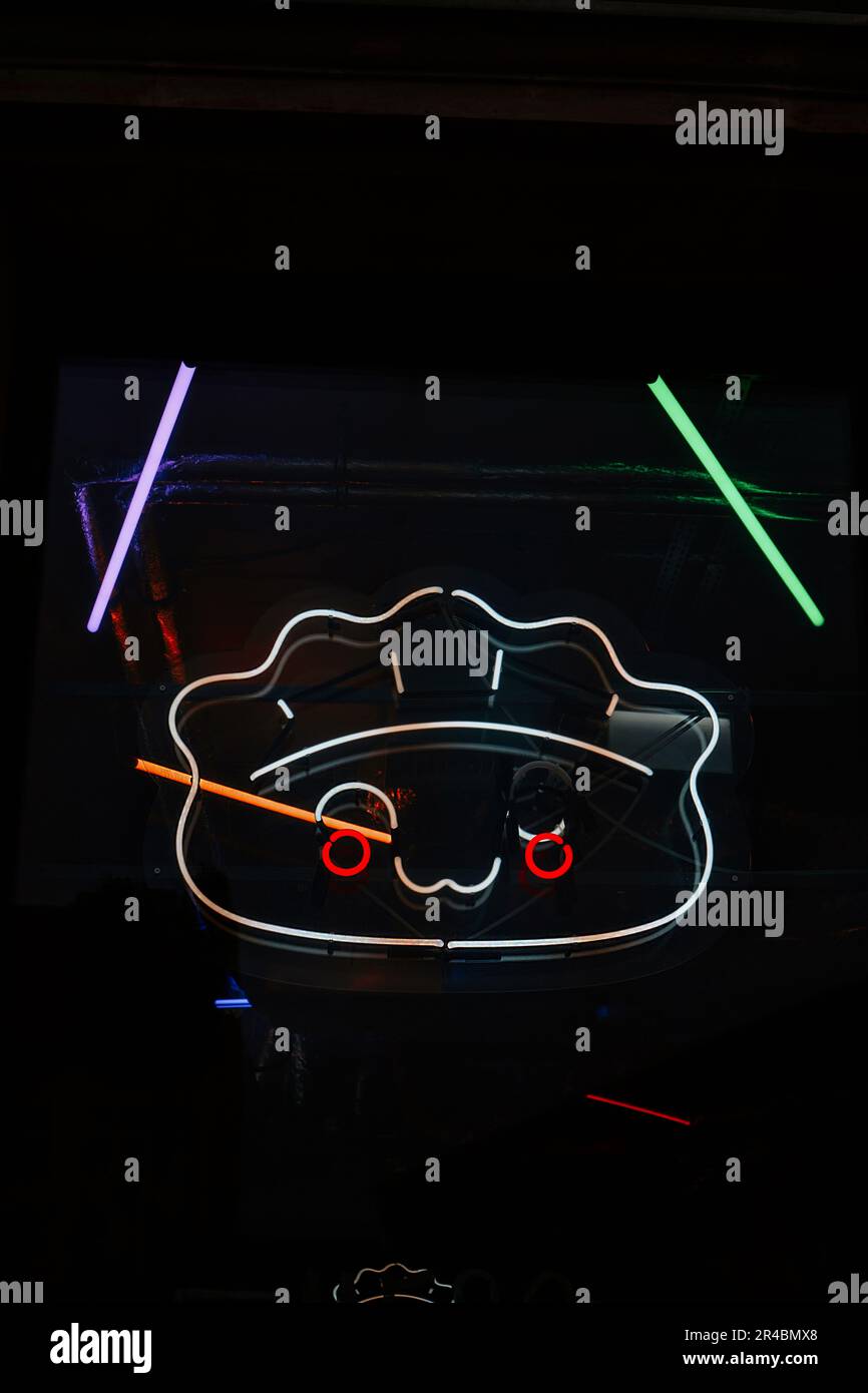 A vibrant neon sign of a traditional Japanese gyoza illuminated against ...