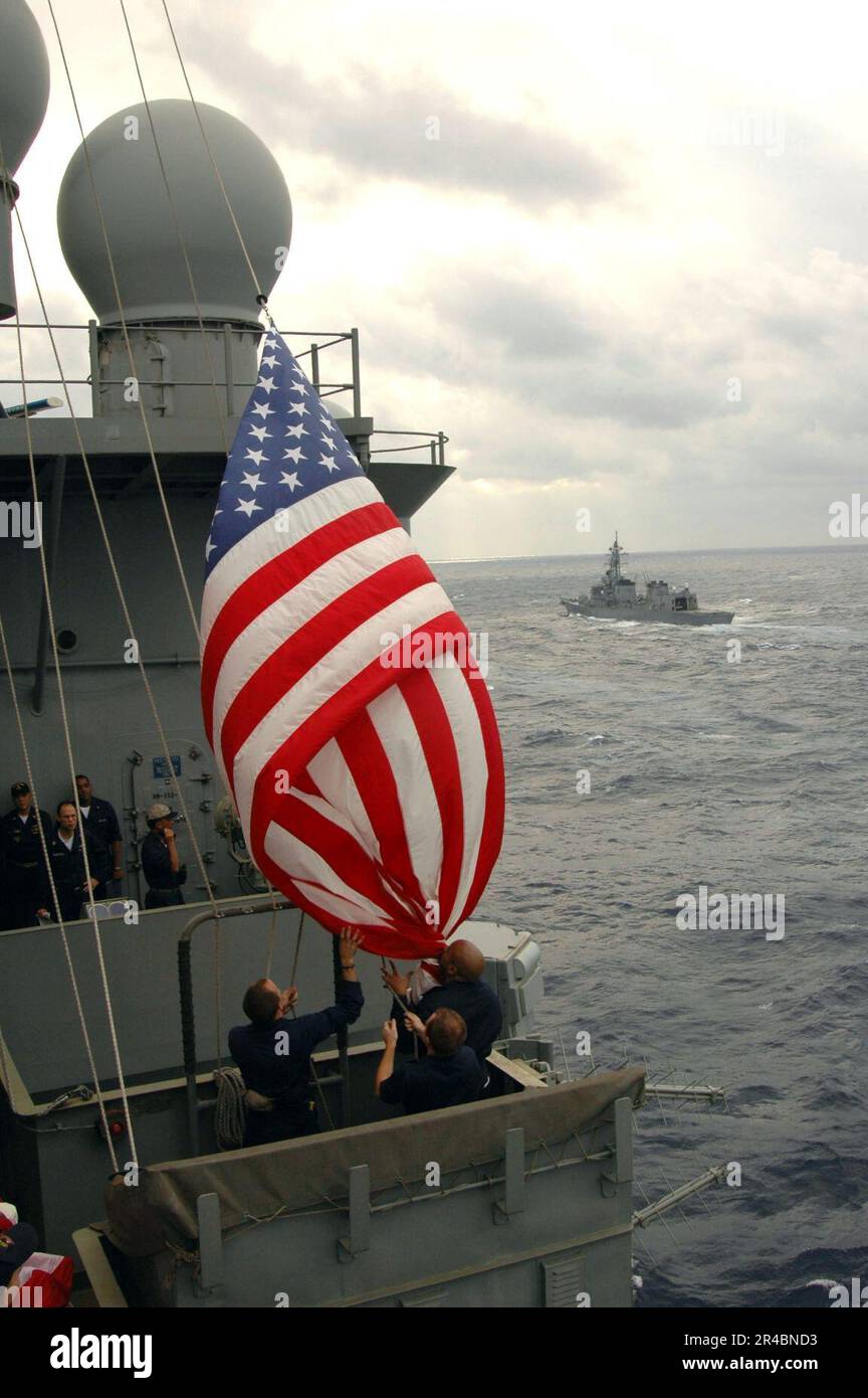 US Navy Navigation Department personnel hoist the holiday Ensign on the ...