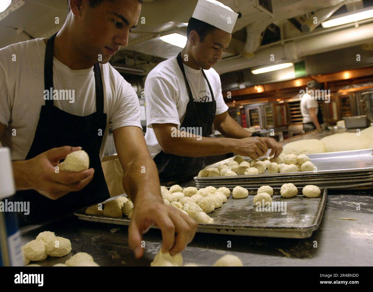 US Navy Airman and Seaman prepare dough to be baked into dinner rolls ...