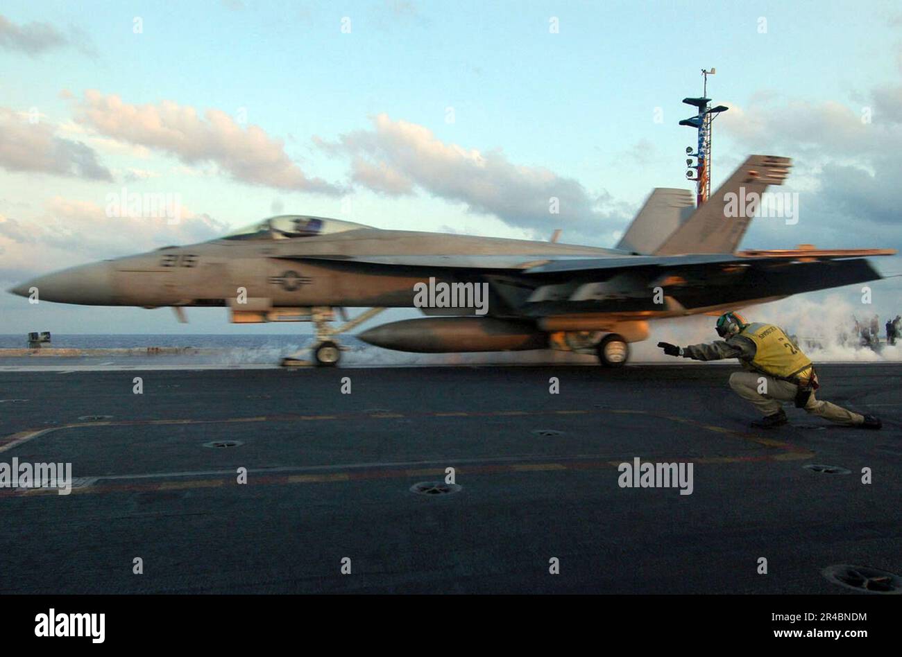 US Navy Lt. Cmdr. signals to launch an F-A-18E Super Hornet, assigned ...