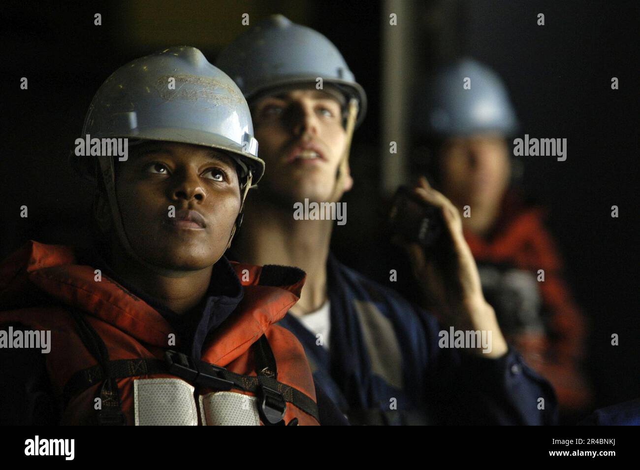 US Navy Seaman foreground, and Seaman Apprentice look-on as cargo is ...