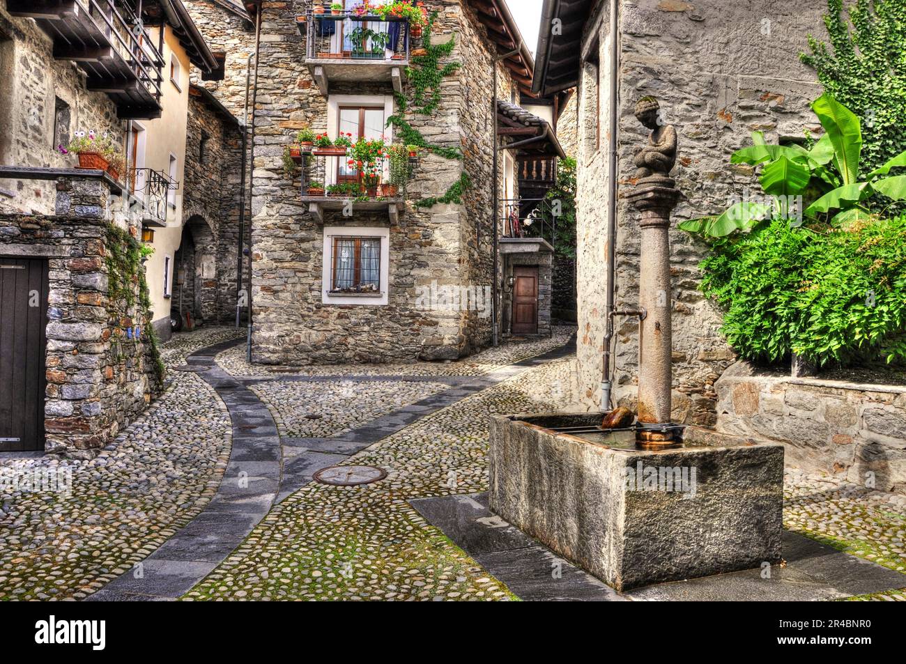 Rustic village with a water well made in stone in Arcegno, Switzerland ...