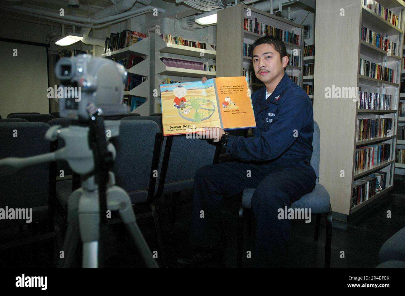 US Navy Ship's Serviceman 2nd Class reads a children's book into a ...