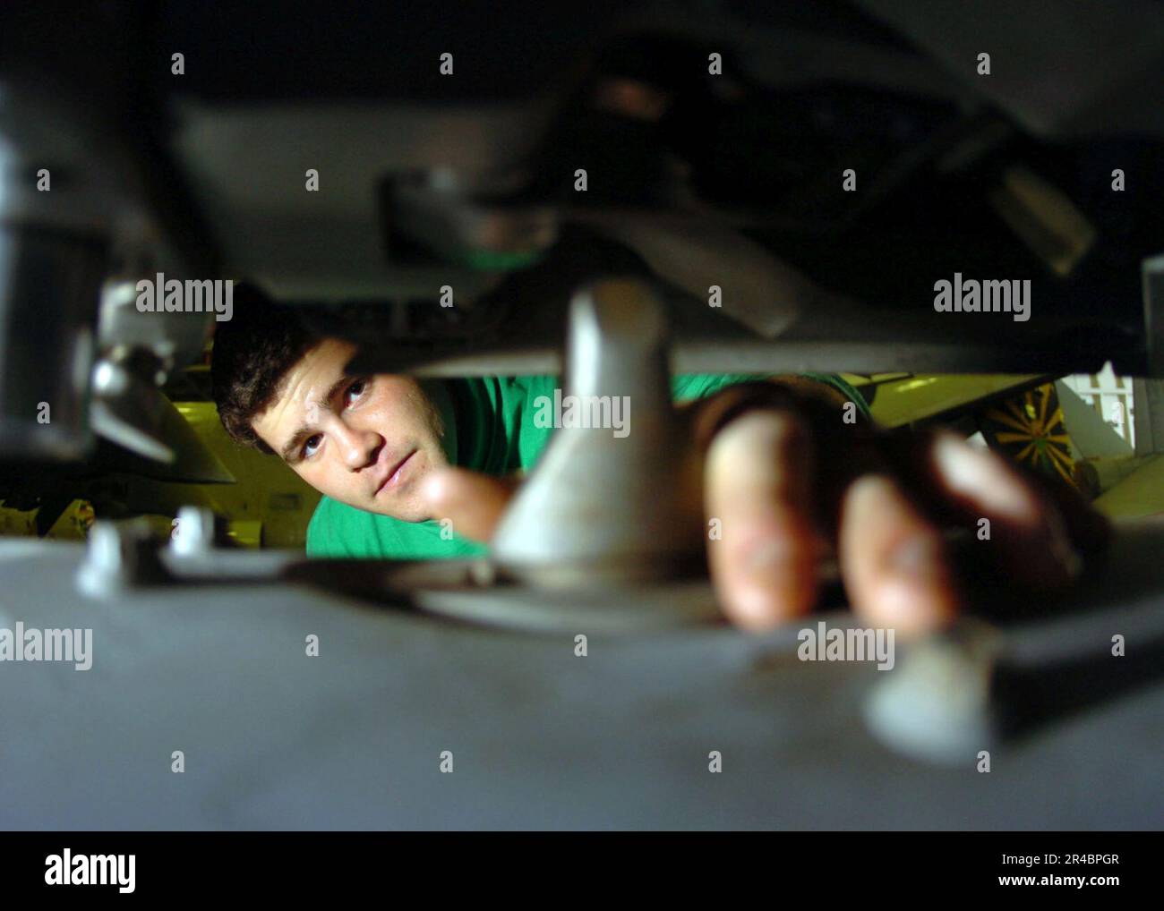 US Navy Aviation Structural Mechanic 3rd Class lines up a hoisting lug ...