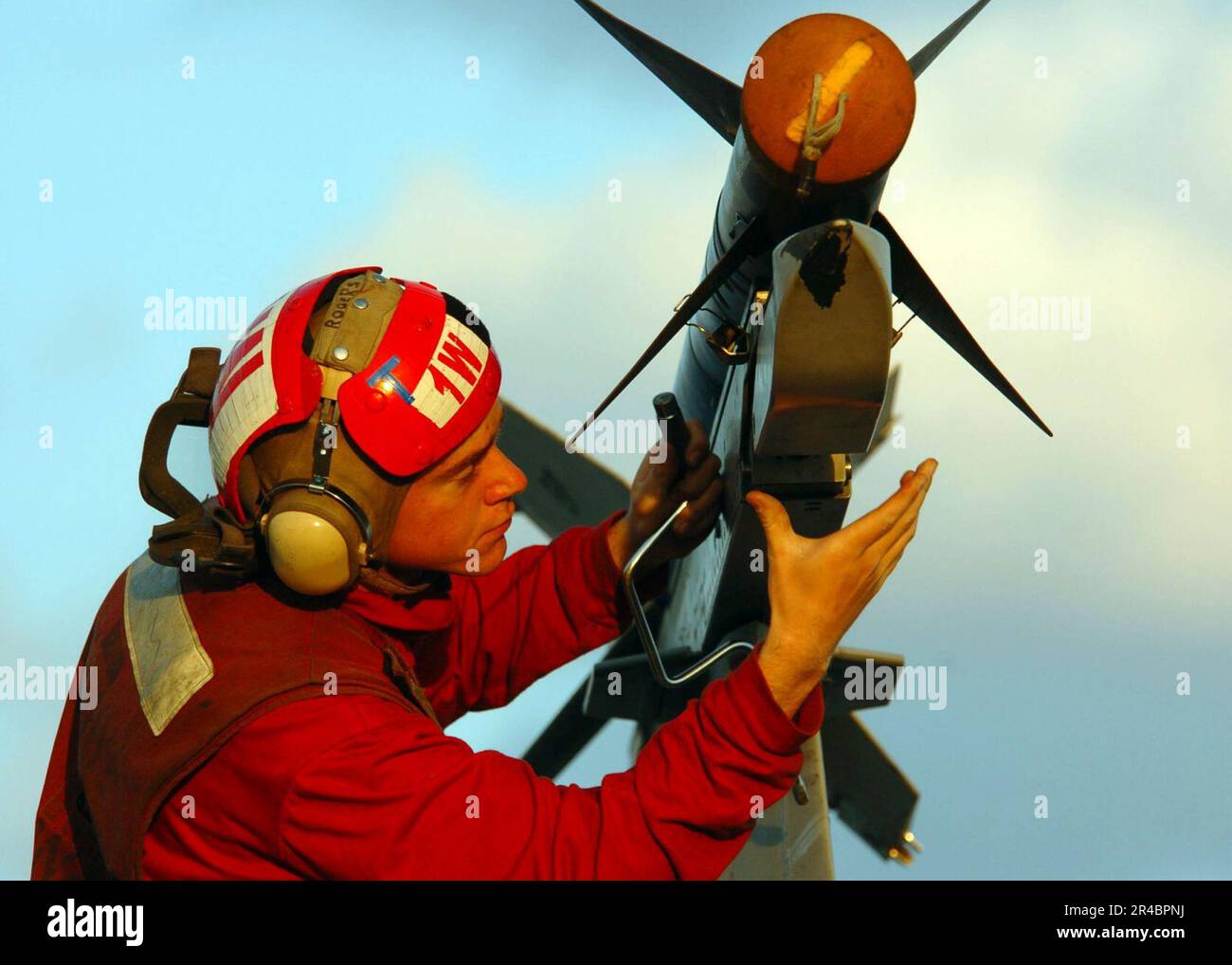 US Navy Aviation Ordnanceman Airman conducts maintenance on a LAU-127 ...