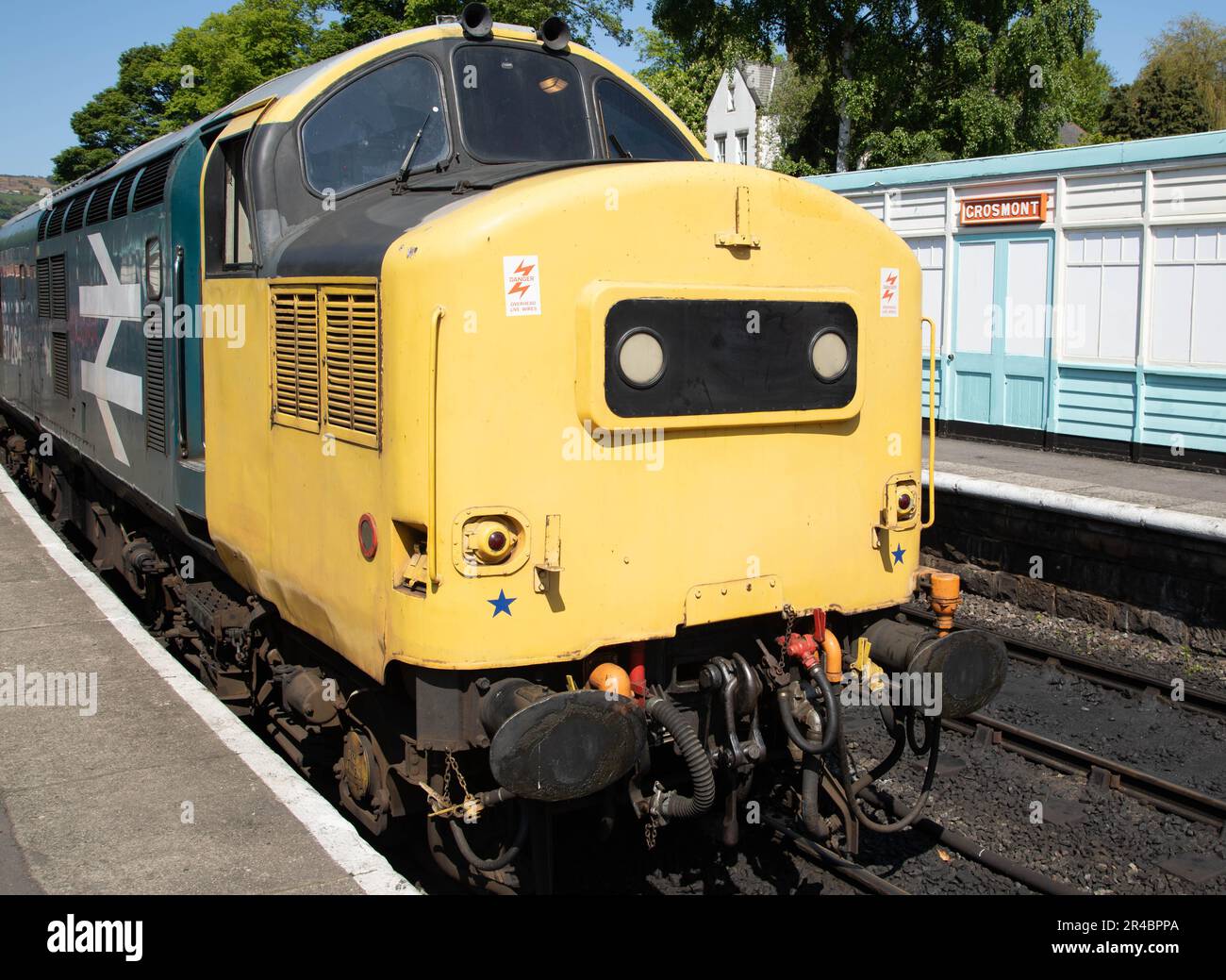 A yellow locomotive parked at a railway station Stock Photo - Alamy