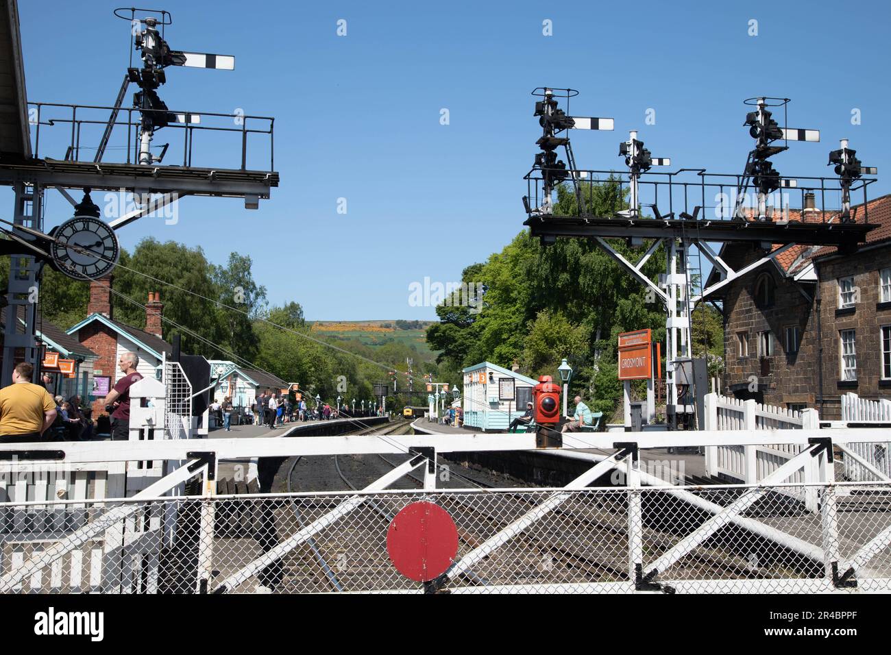 A diverse group of people standing at a railroad crossing in a bustling ...
