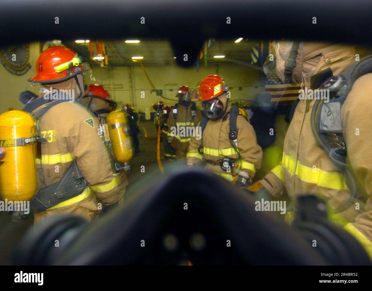 US Navy Sailors deploy a two-inch fire hose in order to combat a ...