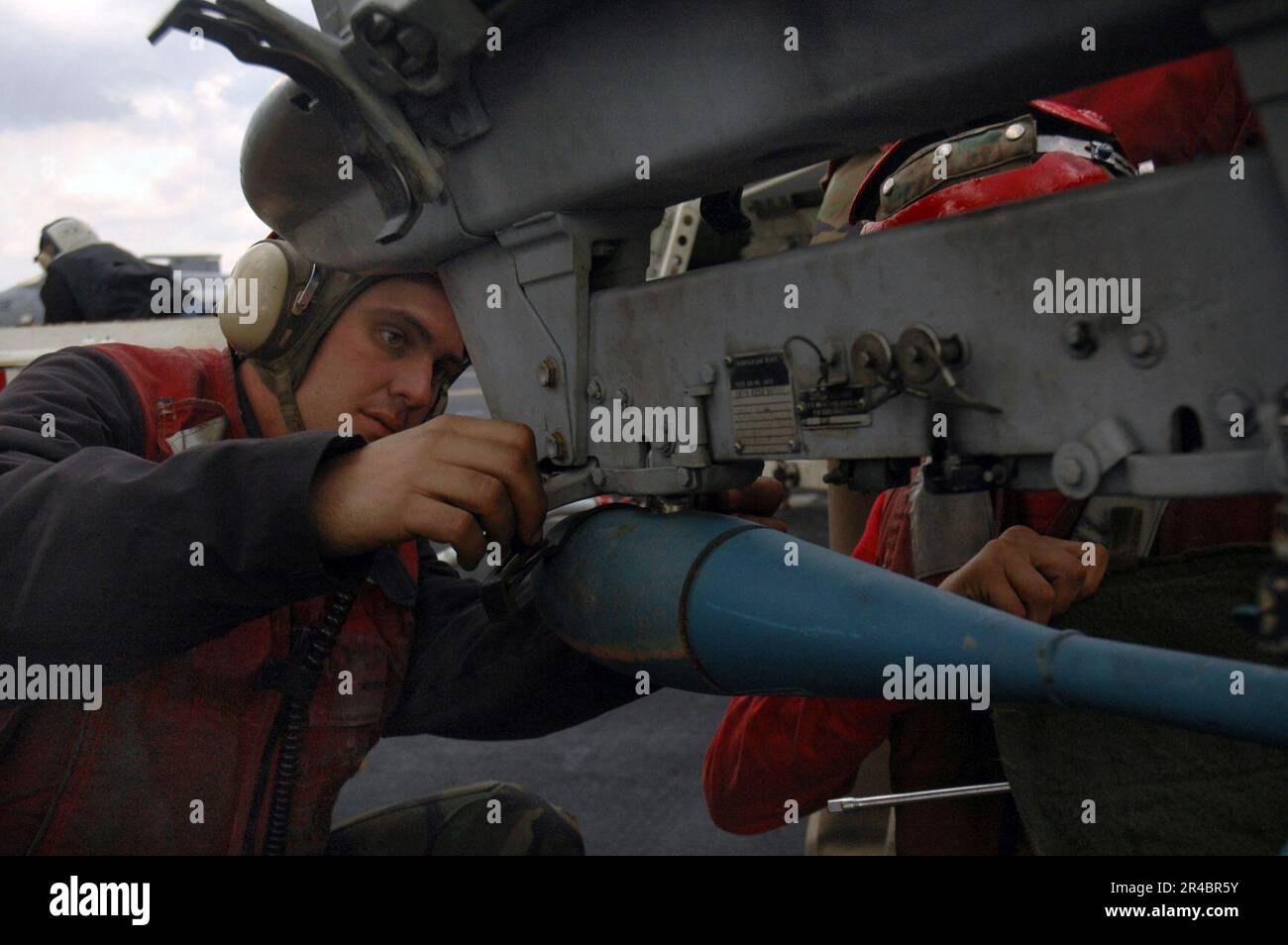 US Navy An Aviation Ordnanceman loads an inert practice bomb on a ...