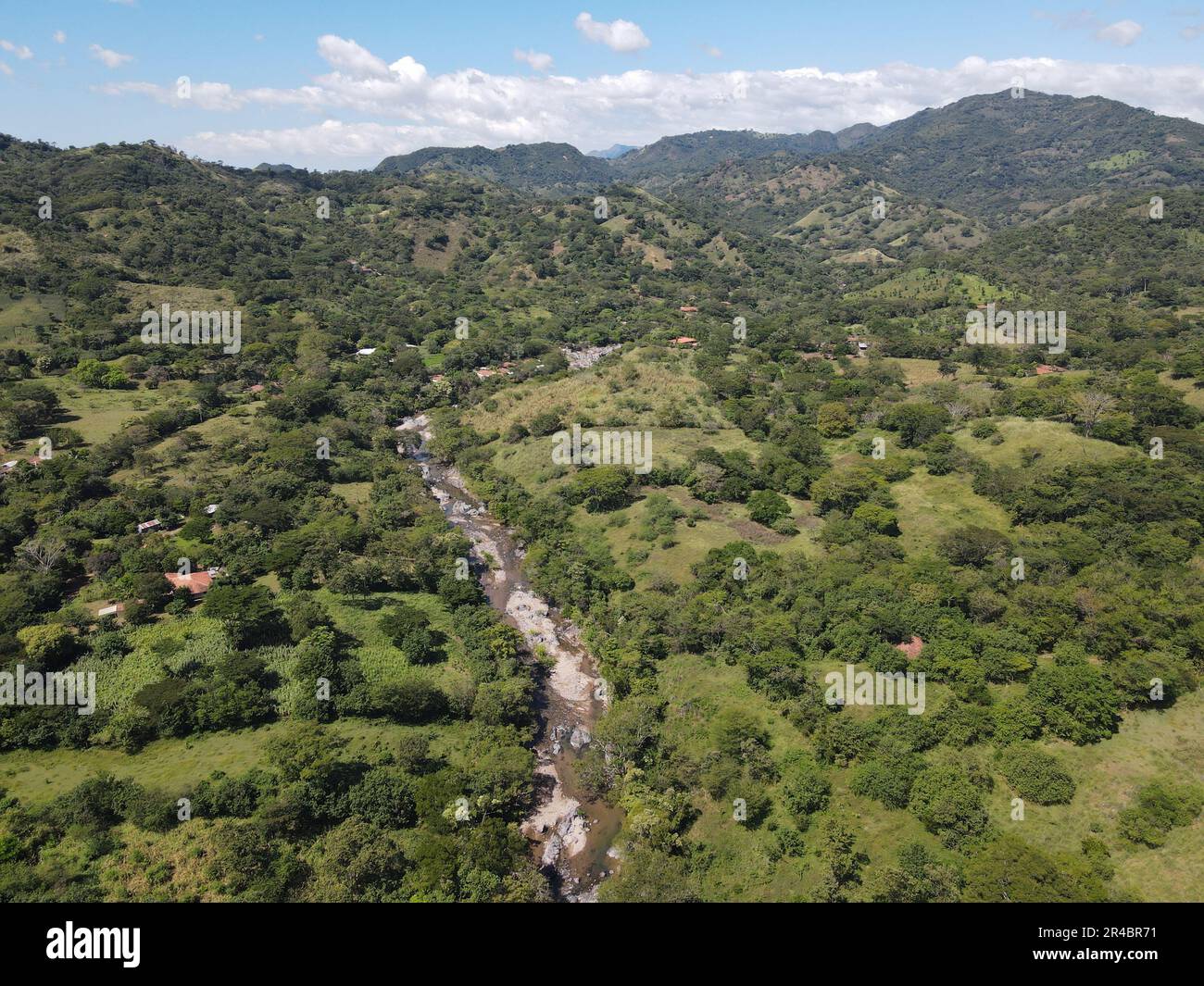 Aerial view of a rocky river, with abundant vegetation on both sides ...