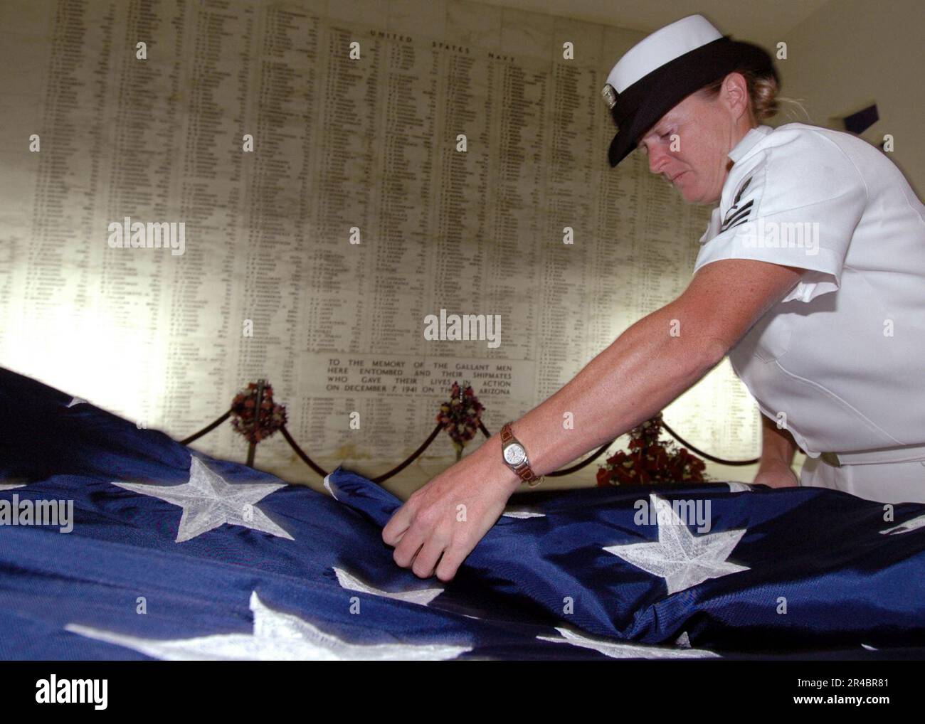 US Navy Machinery Repairman 1st Class folds the National Ensign in the ...