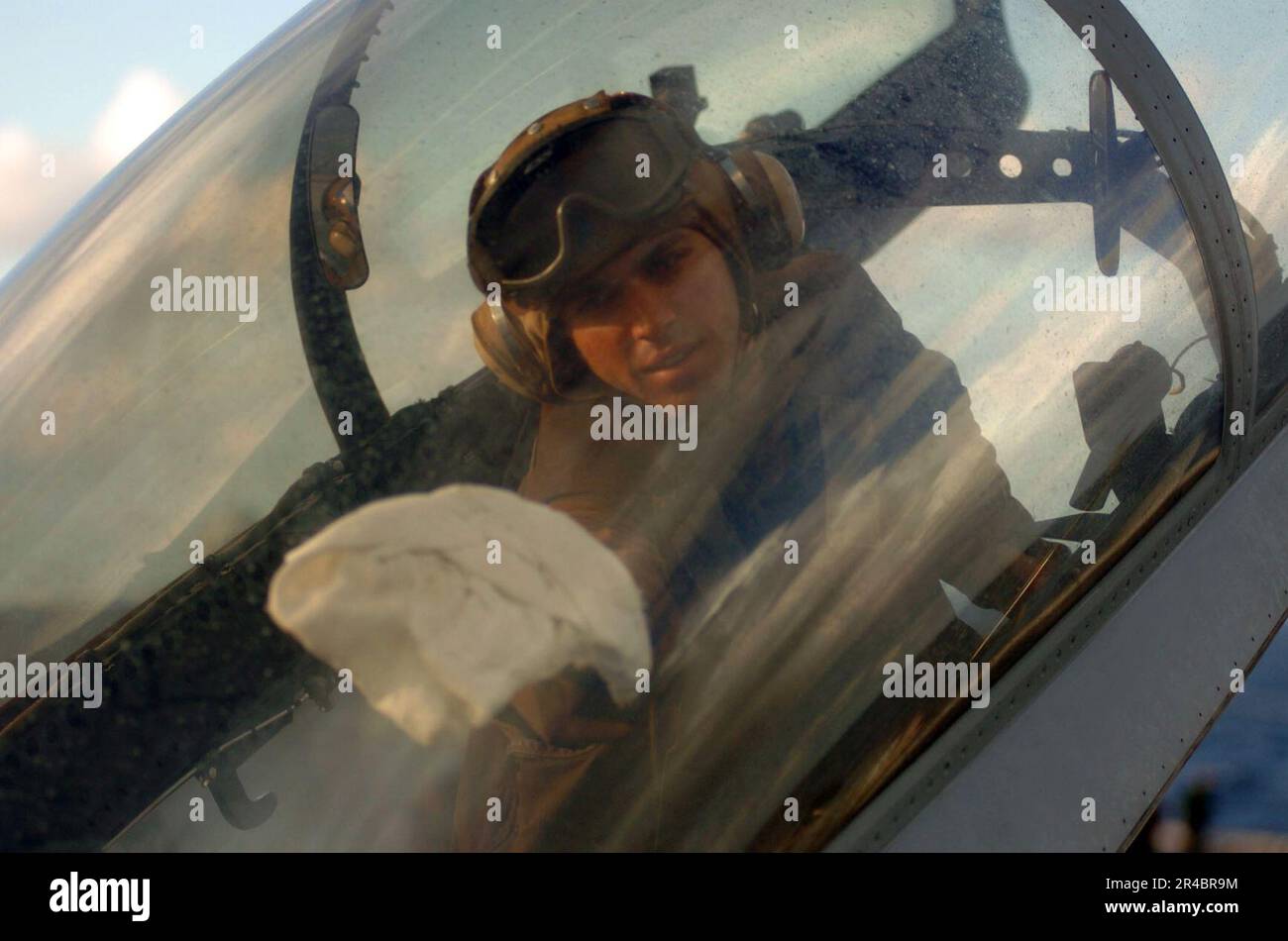 US Navy A plane captain cleans the canopy of one of his squadron's F-A ...